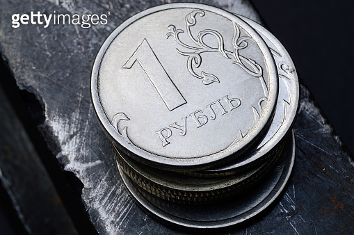 a stack of Russian rubles lies on a scratched metal surface ...
