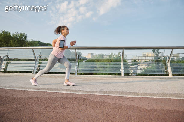 Side full length portrait of a determined active athletic woman running ...