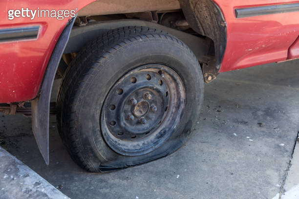 Destroyed blown out tire with exploded, shredded and damaged tire on a ...