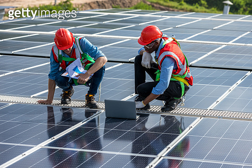 Team Engineer working setup Solar panel at the roof top. Team Engineer ...