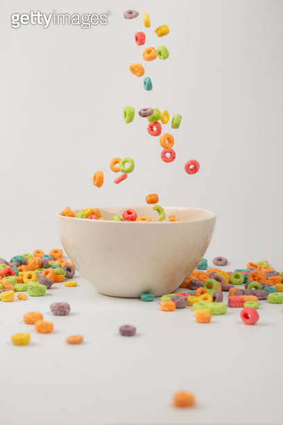 Colorful cereal box for morning breakfast. Corn flakes falling to the ...