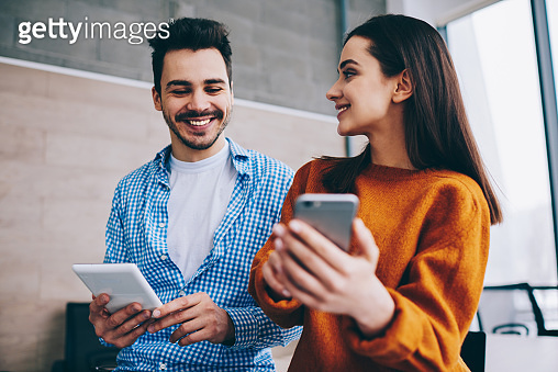 Happy hipster guys connecting to indoors wifi internet for reading ...