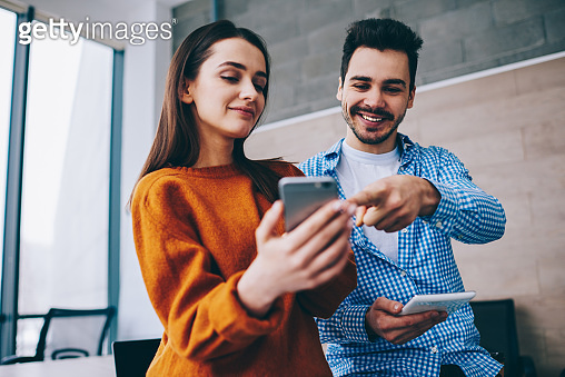 Happy hipster guys connecting to indoors wifi internet for reading ...