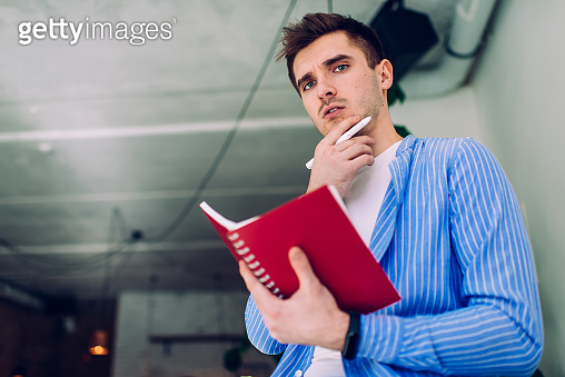 Half length portrait of contemplative male poet with education textbook ...