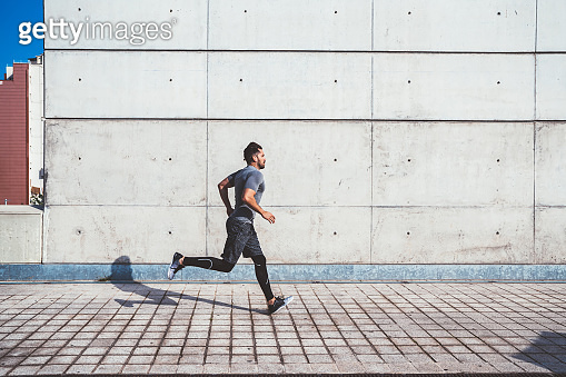 Confident caucasian male runner training strength and flexibility ...