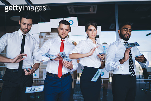 Group of successful male and female investors tossing money during time ...