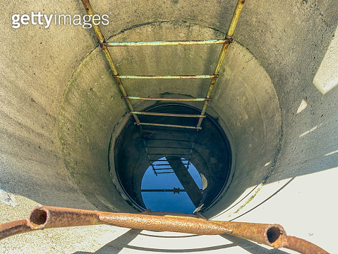 homemade well in the country. concrete rings lowered into the pit ...
