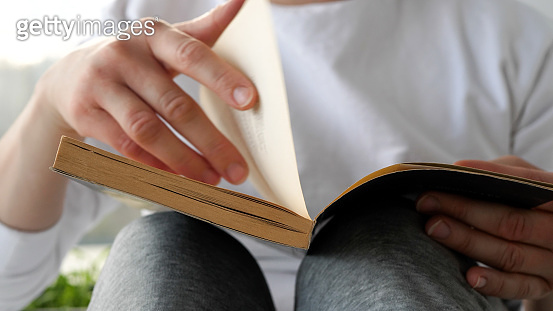 Woman holding book on her knees flipping through pages 이미지 (1391298245 ...