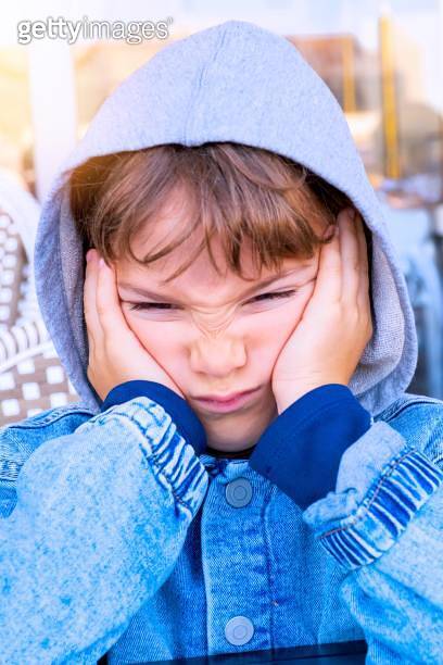 Very disappointed little boy wearing a hood (1411089863) - 게티이미지뱅크