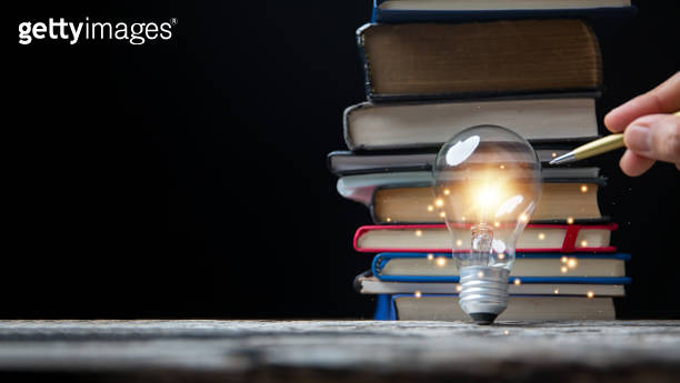 Light bulbs and books. Concept of reading books, knowledge, and searching for new ideas ...