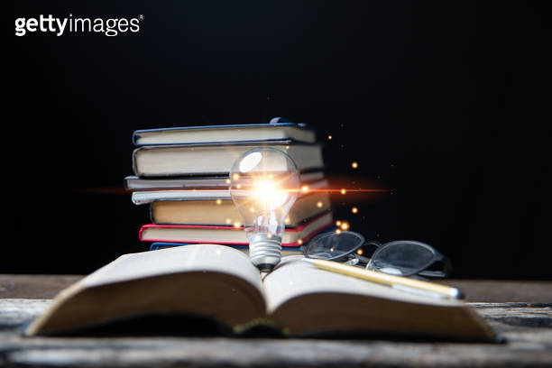Light bulbs and books. Concept of reading books, knowledge, and searching for new ideas ...