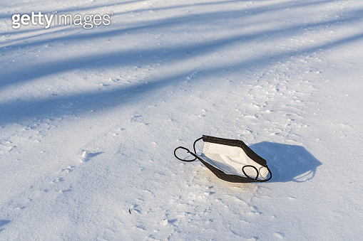 Throw disposable medical mask on winter road. Used hygienic mask during ...