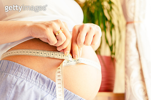 Belly size pregnancy woman measure. Happy young pregnant woman with ...
