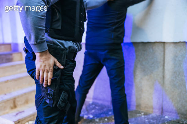Task force officer reaching for a gun while arresting a suspect ...