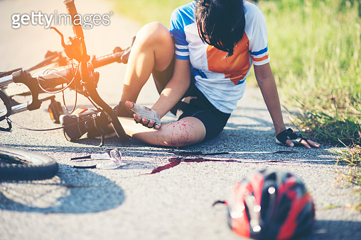 young woman on the ground after bicycle accident and bleeding of blood ...