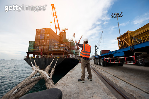 Engineers and crane.smiling dock worker holding radio and Container ...