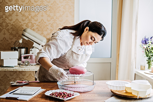 Central Asian Arabic woman pastry chef making Mirror Glaze Mousse cake ...