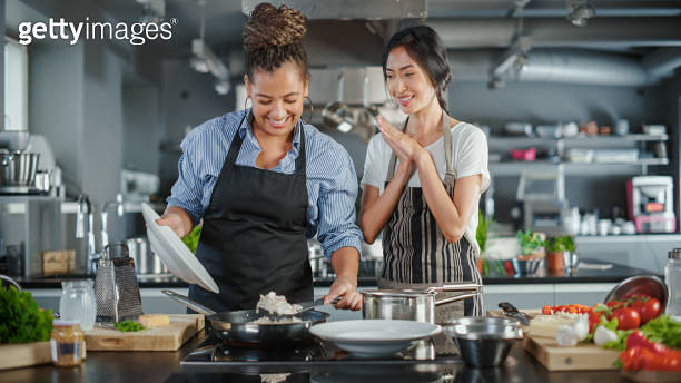 TV Cooking Show Kitchen with Two Master Chefs. Asian and Black Female ...