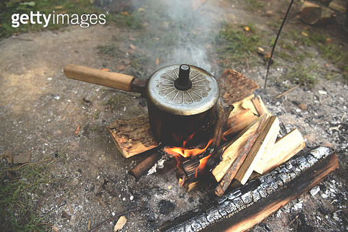 Boiling water on red hot coals in forest. Make campfire cooking. 이미지 ...