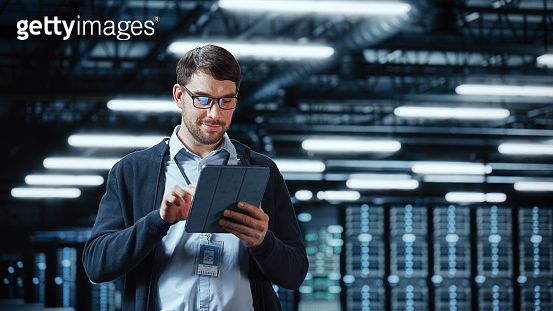Successful Data Center IT Specialist Using Tablet Computer. Server Farm Cloud Computing Facility ...