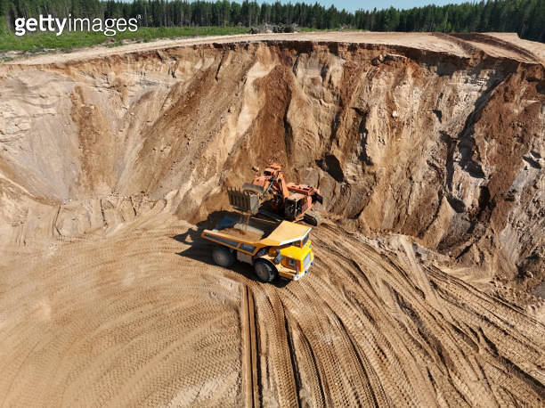 Excavator load sand into mining truck in opencast. Mining excavator in ...
