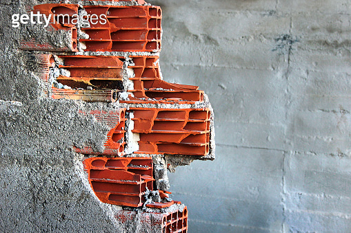 Broken brick wall with shattered bricks protruding from the edge ...