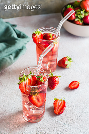 Two glasses with a strawberry cocktail and a bowl of berries. Homemade ...