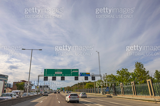 Cityscape view of multi-lane road merging with cloudy blue sky on ...