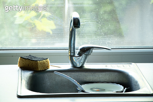 dirty dishes in the sink on the table in the kitchen under the tap ...