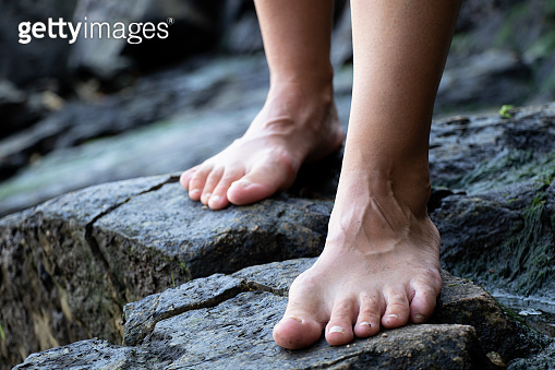 female bare feet on granite stones at the quarry, bare feet on the ...