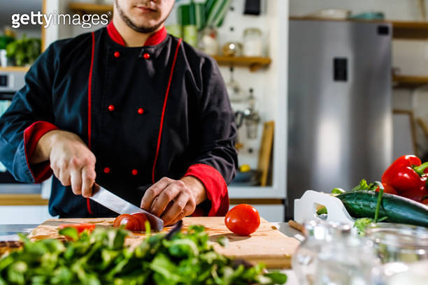 Cut out shot of professional chef cutting up tomato for a salad 이미지 ...