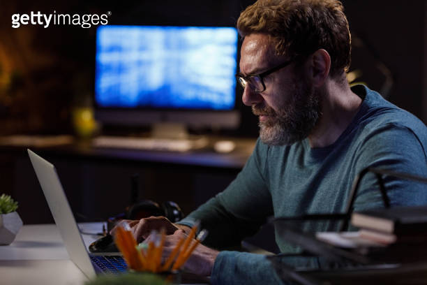 Portrait of serious computer programmer typing code on laptop when ...