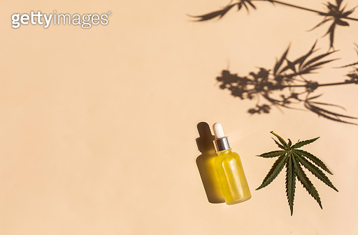 glass bottle with CBD oil, THC tincture on a pastel background with ...