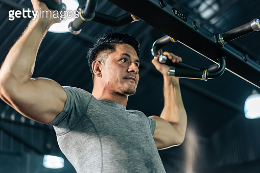 Caucasian sportsman slowly lift up weight machine barbell in stadium ...
