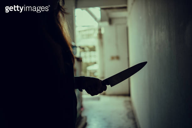 The shadow of a female murderer stood terrifyingly holding a knife and ...