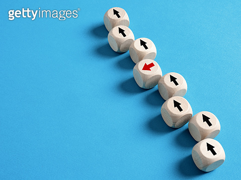 Arrow signs on wooden cubes forming a pathway with one arrow stands out ...