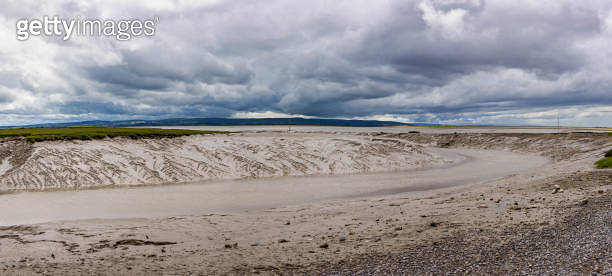 Mud flats on an estuary at low tide on the Bristol Channel coast in the ...