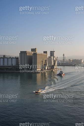 Pilot boat sailing bay the Ergransa agricultural grain silos at the ...