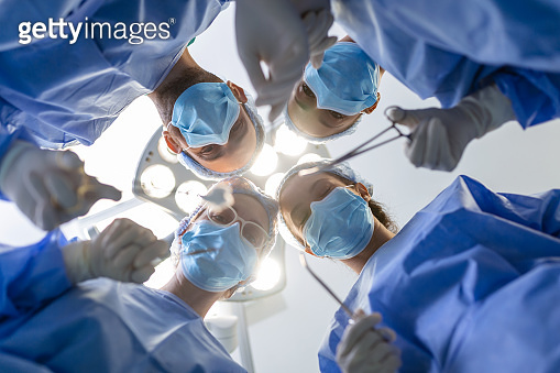 Surgeons standing above of the patient before surgery. Multi-ethnic ...