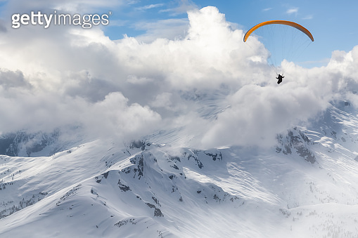 Adventure Composite Image of Paraglider Flying up high in the Rocky ...