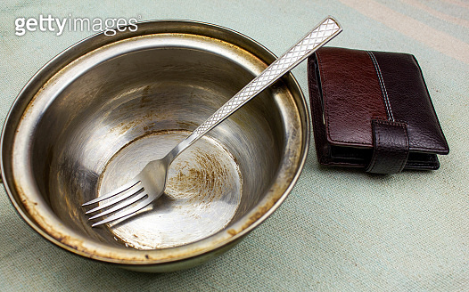 Hunger concept. Wallet and fork in an empty metal plate. Hunger and ...