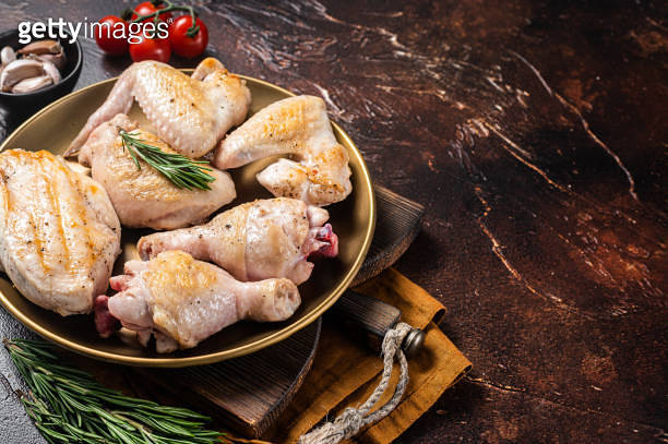 Assortment of Roast chicken meat parts on a plate. Drumstick, breast ...