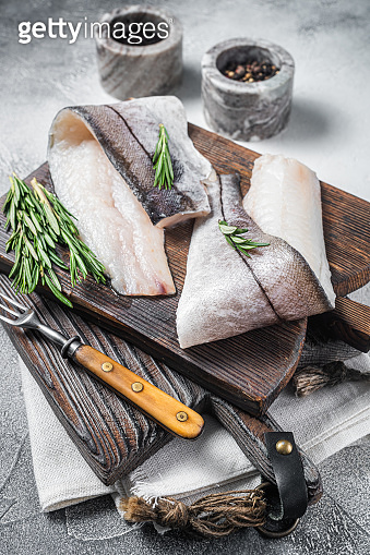 Haddock fish fillet, raw seafood meat on wooden board with herbs. White ...