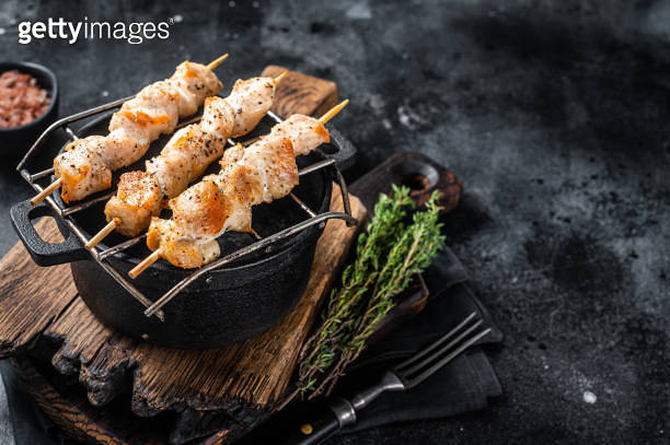 Grilled Chicken skewers souvlaki, poultry meat shish kebab. Black background. Top view. Copy ...