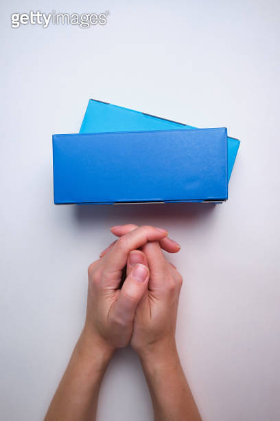 A woman holds small blue paper boxes in her hand. Postal services ...