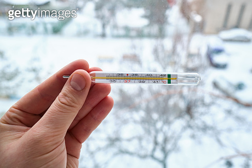 Medical thermometer close-up in the hands of a man. Traditional ...