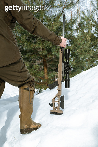A sniper rifles from a rifle with an optical sight in man`s hands ...
