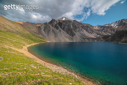 Deep mountain lake of phantom blue color among high mountains with ...