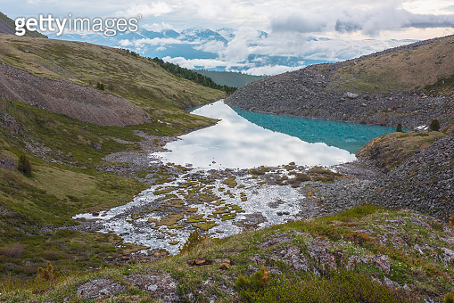 Colorful landscape with azure mountain lake with cloudy sky reflection ...