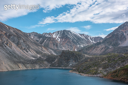 Deep mountain lake of phantom blue color among sharp rocks and high ...